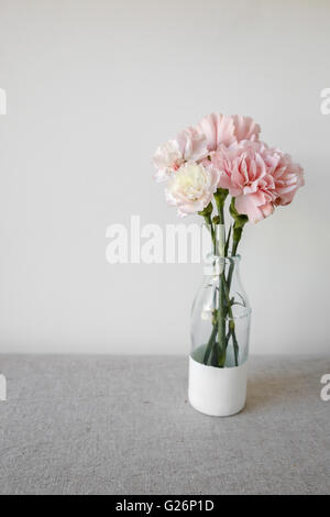 Vase of pastel pink carnation flowers on wooden table Stock Photo - Alamy