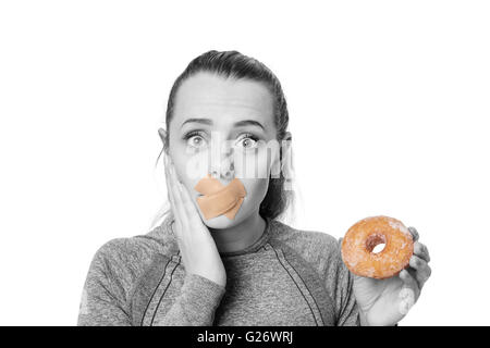 woman with first aid plaster over mouth unable to eat a donut Stock ...