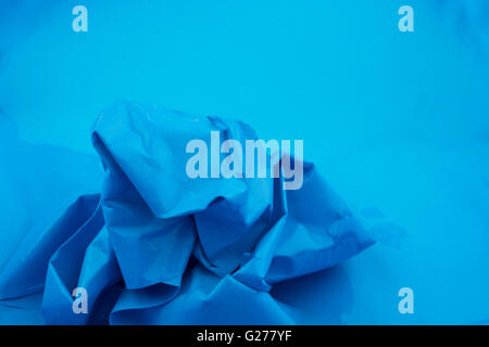Crumpled paper put in water in blue background Stock Photo - Alamy