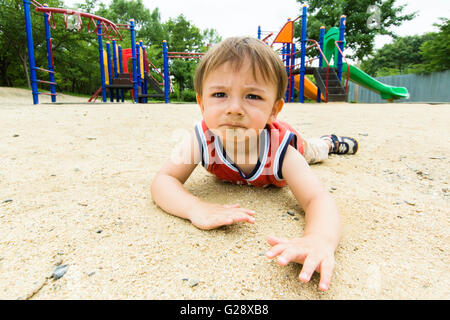 Kid falling down on the ground in summer park. Moment of the fall down ...