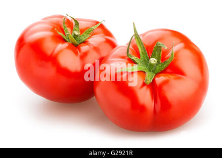 Two vibrant red tomatoes with green stems on a white textured surface ...
