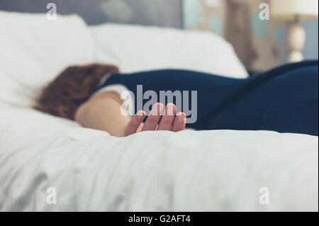 A young woman wearing a dress is passed out on a bed Stock Photo - Alamy