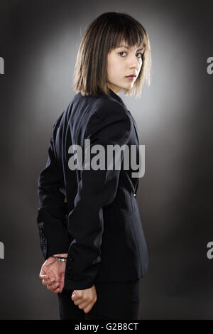 locked up business woman in handcuffs with her hands up Stock Photo - Alamy