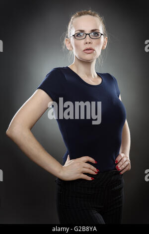 Studio shot of a serious looking receptionist, wearing glasses ...