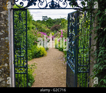 Gardens at Rousham House, Oxfordshire, UK; archway and planting inside ...