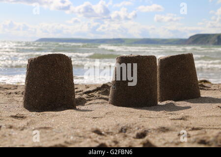 Three sandcastle towers on a beach Stock Photo - Alamy