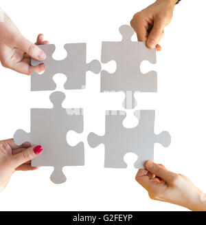 Close up of hands connecting puzzle element and making jigsaw complete ...