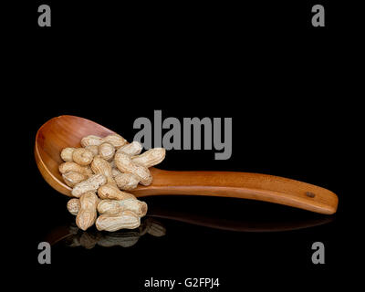 Peanuts in Wooden Spoon On A Wooden Background. Spilled Salted Peanuts ...