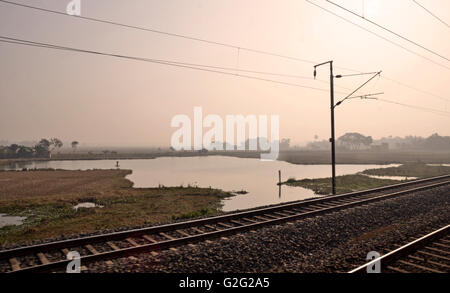Indian countryside as viewed from the footboard of a running train ...