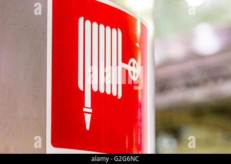 fire hose signal on red background Stock Photo - Alamy