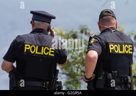 OPP (Ontario Provincial Police) officers unloading equipment from a bus ...