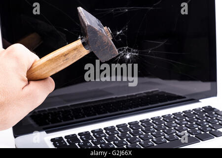 Hand with a hammer and laptop with a broken screen Stock Photo - Alamy