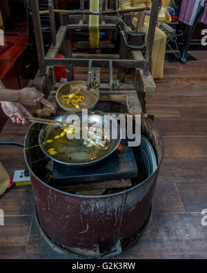 Silk worm workers working with the cocoons and fine threads in the silk ...