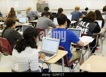 Students taking a test on laptops in a high school classroom. The test ...