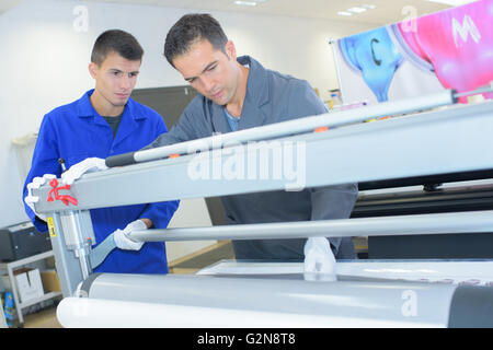 men fixing industrial printing machine Stock Photo - Alamy
