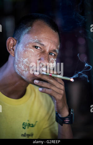 Portrait of a Burmese young man wearing traditional make-up (thanakha ...
