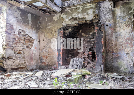 A derelict house with the upper floor and roof missing and plaster ...