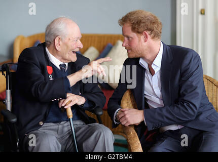 Prince Harry speaks to Anthony Colgan, 92, during a reception with ...
