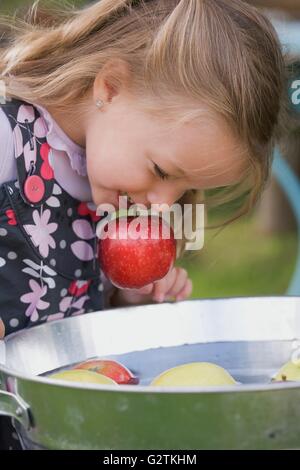 A girl bobbing for apples Stock Photo - Alamy