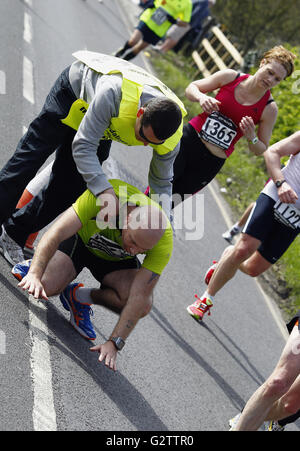Collapsed male runner being helped by St John Ambulance team during ...