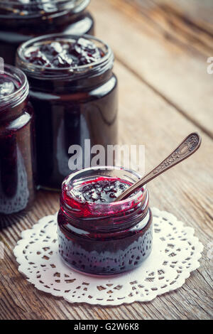 Spoon with plum jam on the retro decorated desk with fruit and glass ...