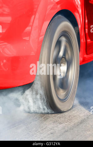 Car wheel burn rubber with spin circle motion on the asphalt road and ...