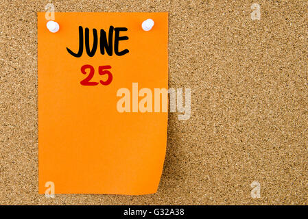 4 JUNE written on orange paper note pinned on cork board with white thumbtacks, copy space ...
