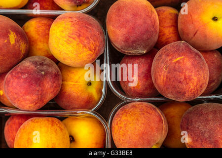 Tasty fresh ripe peaches and a punnet on a table Stock Photo - Alamy