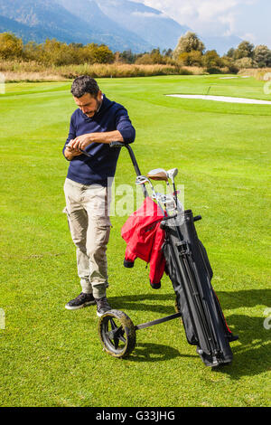 Confident man playing golf at field Stock Photo - Alamy