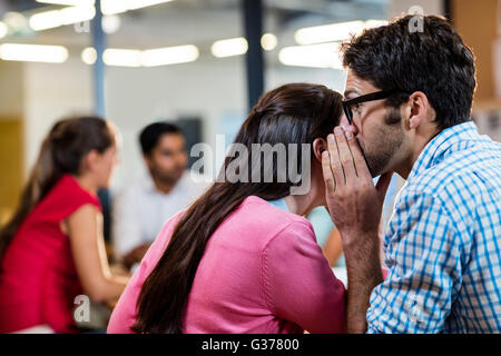 Casual colleagues whispering Stock Photo - Alamy