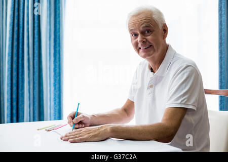 Senior man using a colouring book Stock Photo - Alamy