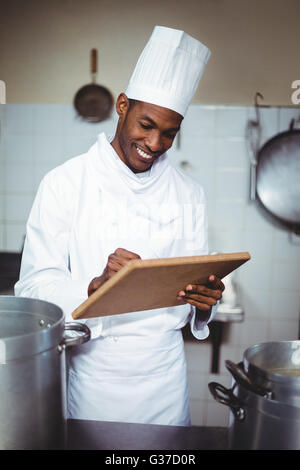 Chef making notes on a clipboard Stock Photo - Alamy