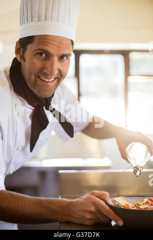 Portrait of happy smiling male with a olive oil bottle in his hand ...
