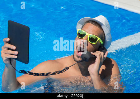 Guy having a call from a swimming pool Stock Photo - Alamy
