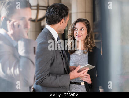 Smiling businesswoman with digital tablet listening during meeting in ...