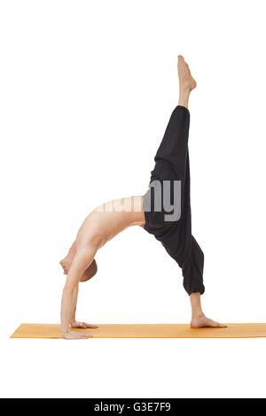 Flexible man posing in difficult yoga pose Stock Photo - Alamy