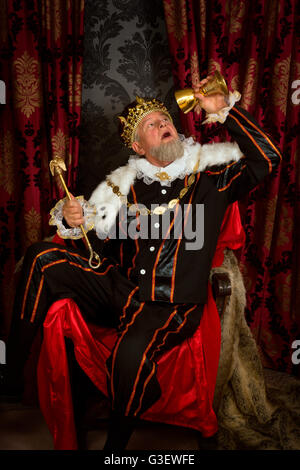 Old funny king getting drunk holding a golden goblet Stock Photo - Alamy