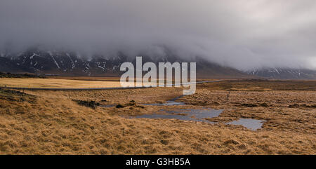 Typical dramatic Icelandic landscape with empty road and mountains ...