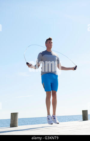 Man jumping with a blue skipping rope Stock Photo - Alamy