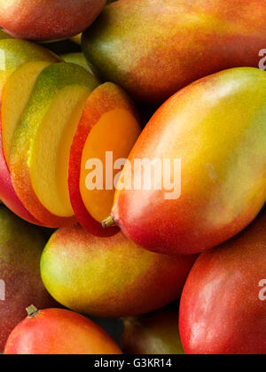 Close up fresh whole mangoes. Two tropical mango fruits on black wooden ...
