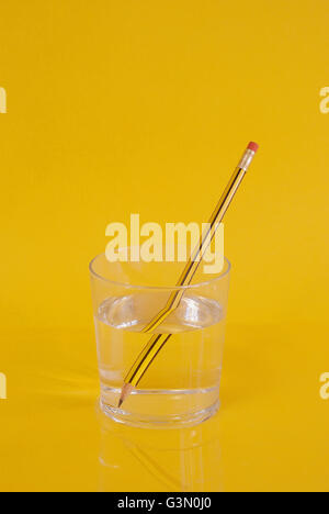 Refraction of an image of a pencil in water. The pencil appears bent ...