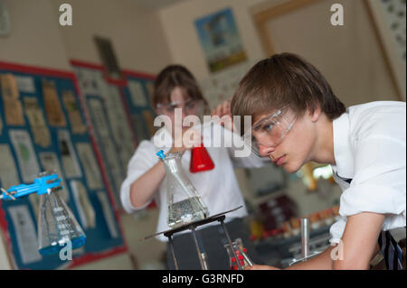Secondary school lab partners taking part in a chemistry experiment in ...