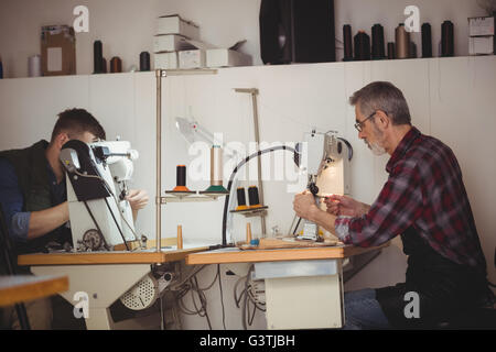 Profile view of cobbler using a sewing machine Stock Photo - Alamy