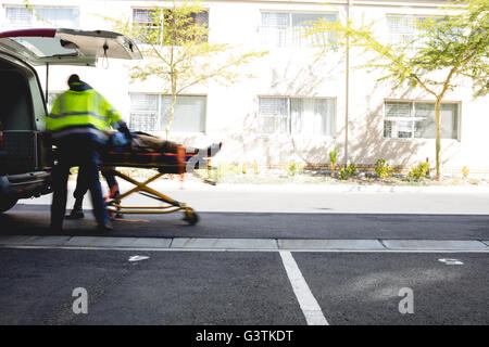 Ambulancemen carrying injured man on a stretcher Stock Photo - Alamy