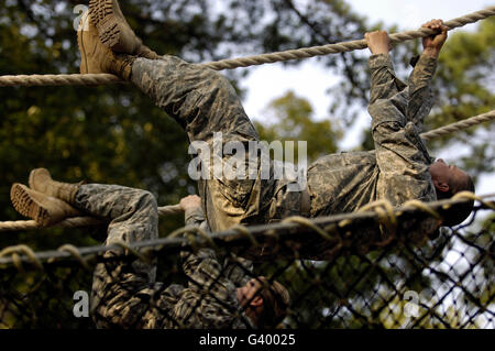 Military soldier climbing rope during obstacle course training at boot ...