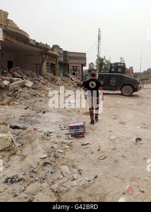 Fallujah, Iraq. 17th June, 2016. An Iraqi soldier stands near destroyed ...