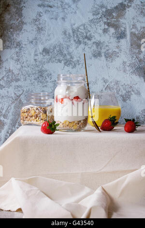 Strawberry granola or smoothie in glass and fresh berries in wooden ...