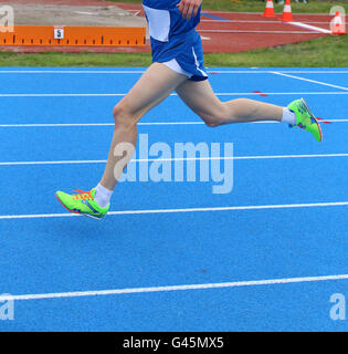 long legs of fast runner runs into the blue in athletics track Stock ...