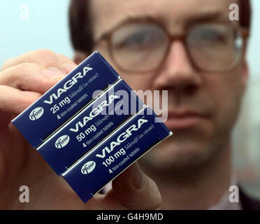 Dr Jonathan Reggler holds up packets of Viagra at his surgery in Marlow ...