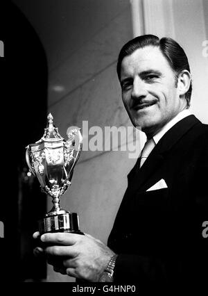 Race driver Graham Hill holds the winner's cup he received from ...